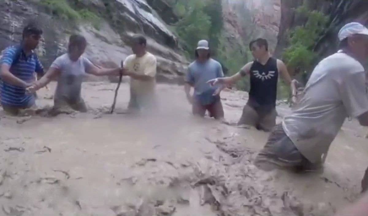 Hikers cross flash flood in Zion National Park with a little help